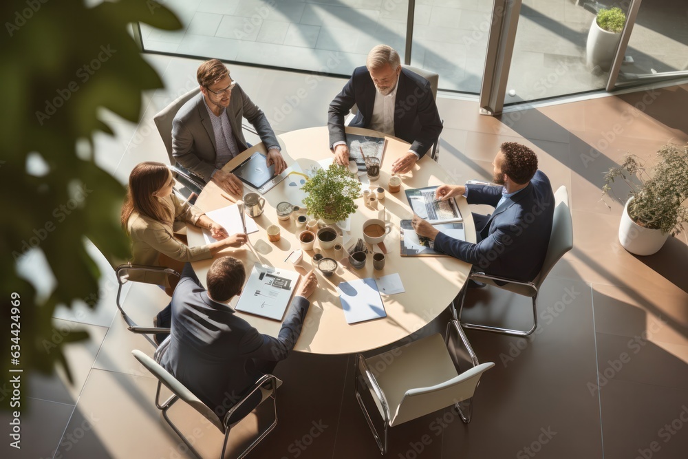aerial shot of round table with researchers office meeting engaged in a ...