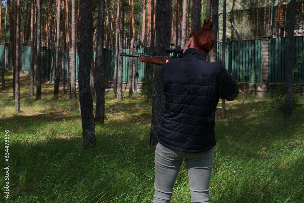 Young redhead woman protecting her house or on tactical gun training ...