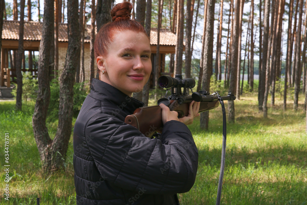 Young redhead woman protecting her house or on tactical gun training ...
