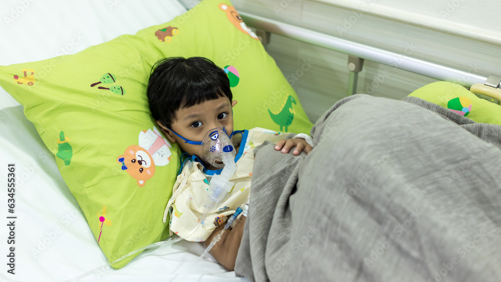 Sick boy inhalation therapy by the mask of inhaler. Baby has asthma and ...