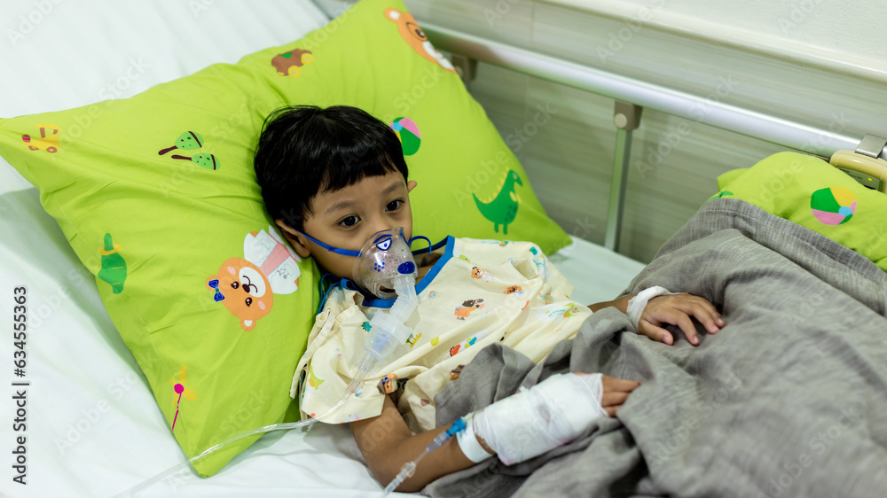 Sick boy inhalation therapy by the mask of inhaler. Baby has asthma and ...