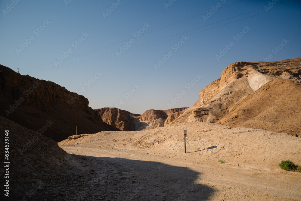 A hiking path with a trail marker, in the barren hills of the Judean ...