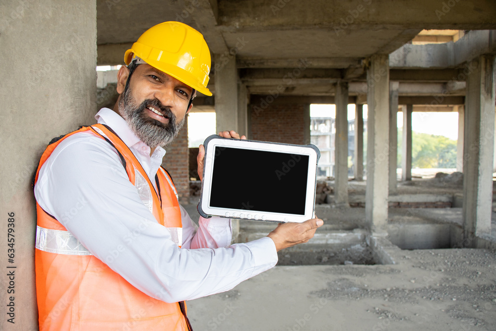 Mature Indian male civil engineer or architect wearing helmet and vest ...