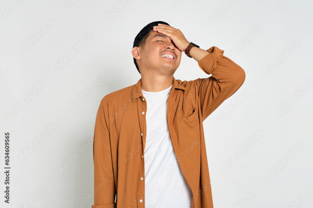 Forgetful young Asian man in casual shirt slapping hand on head having ...