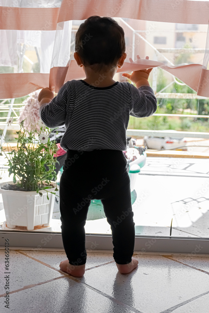 Unrecognizable little kid bare feet at home rear view from his back ...