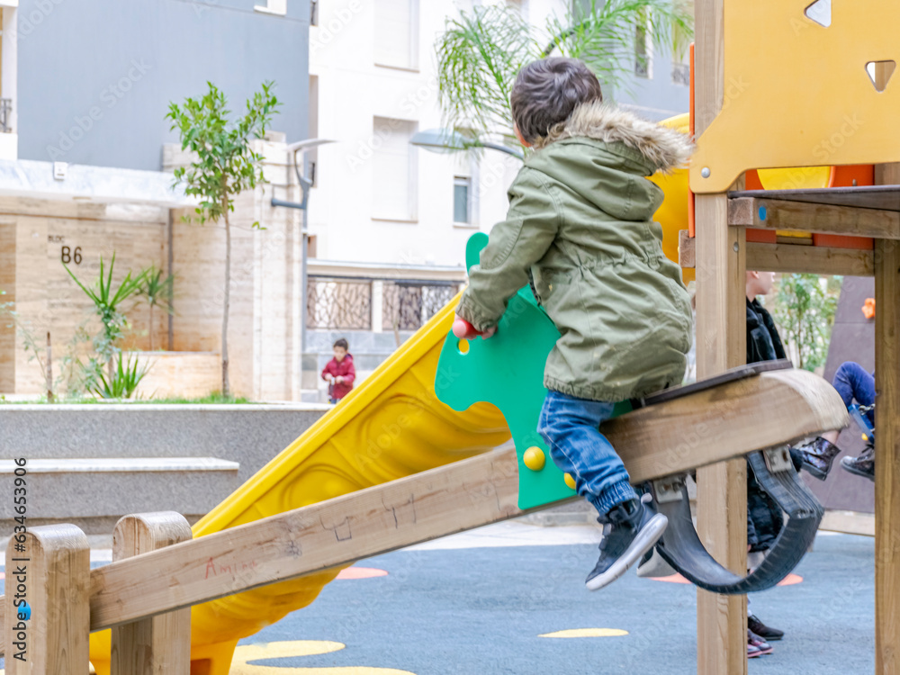 A kid playing in a seeaw playground open air amusement park a public ...