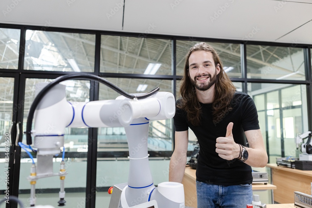 Male staff engineer thumb up with robot for education on table at class ...