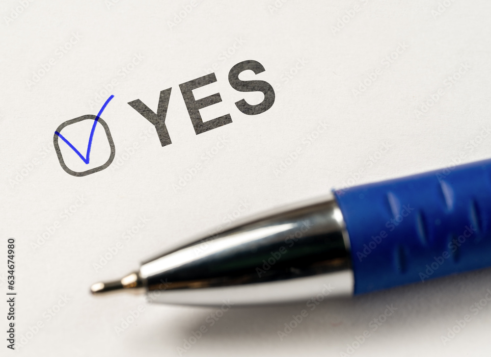 checkbox YES. marked with tick mark and blue pen on white paper ...