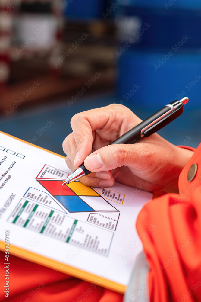 A safety engineer is using pen to rating the health risk assessment ...