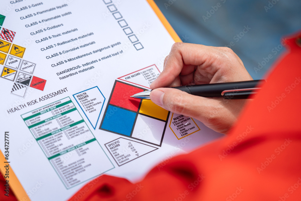 A safety engineer is using pen to rating the health risk assessment ...