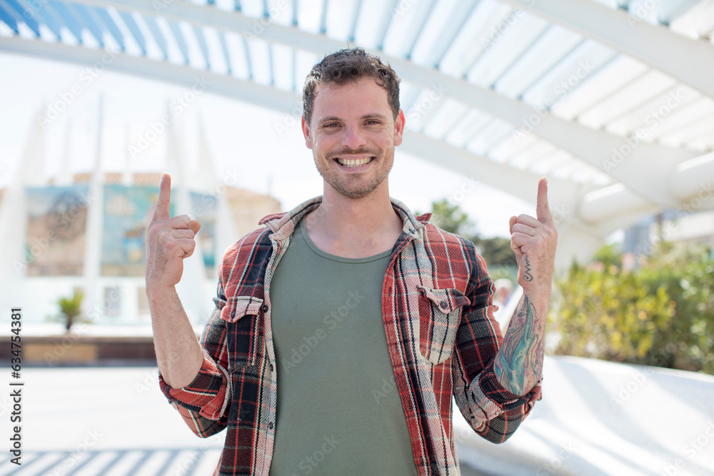 handsome man feeling awed and open mouthed pointing upwards with a ...