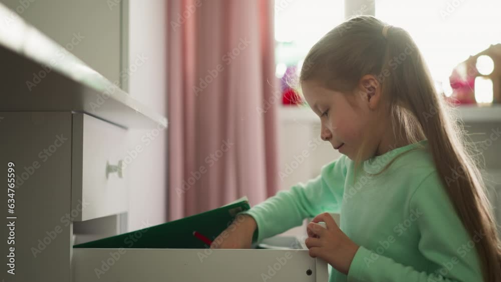 Happy girl finds new color markers pack under folder in desk drawer in ...
