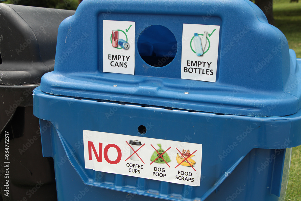 large blue recycle bin with circle opening and white sticker captions ...