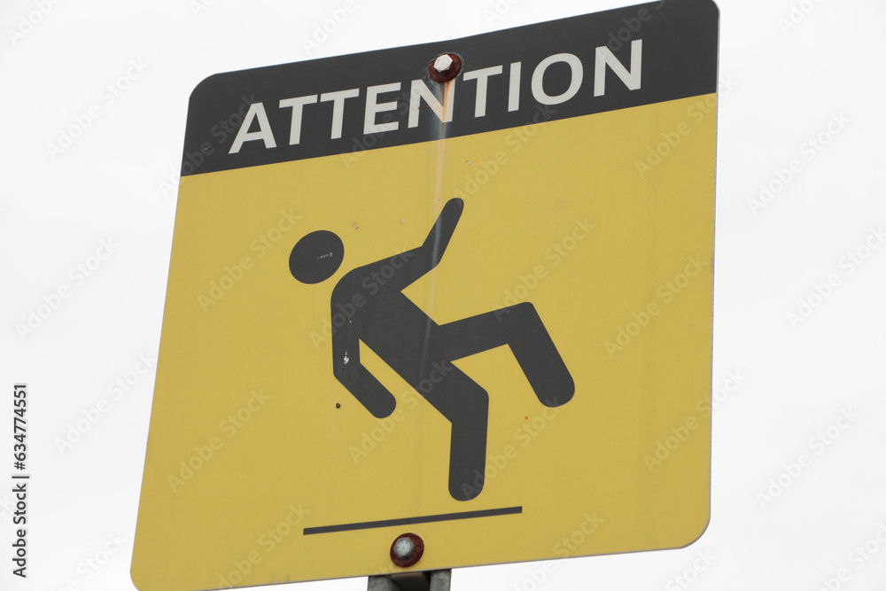 yellow square rectangle sign that says attention in capital letters ...