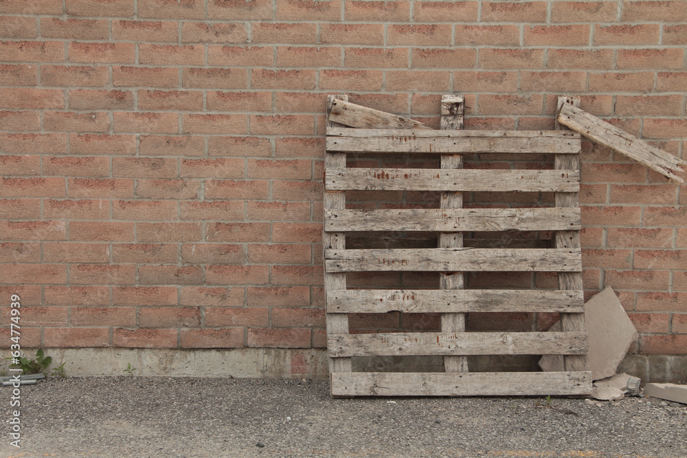 broken wood colored palette skid standing right side up on pavement ...