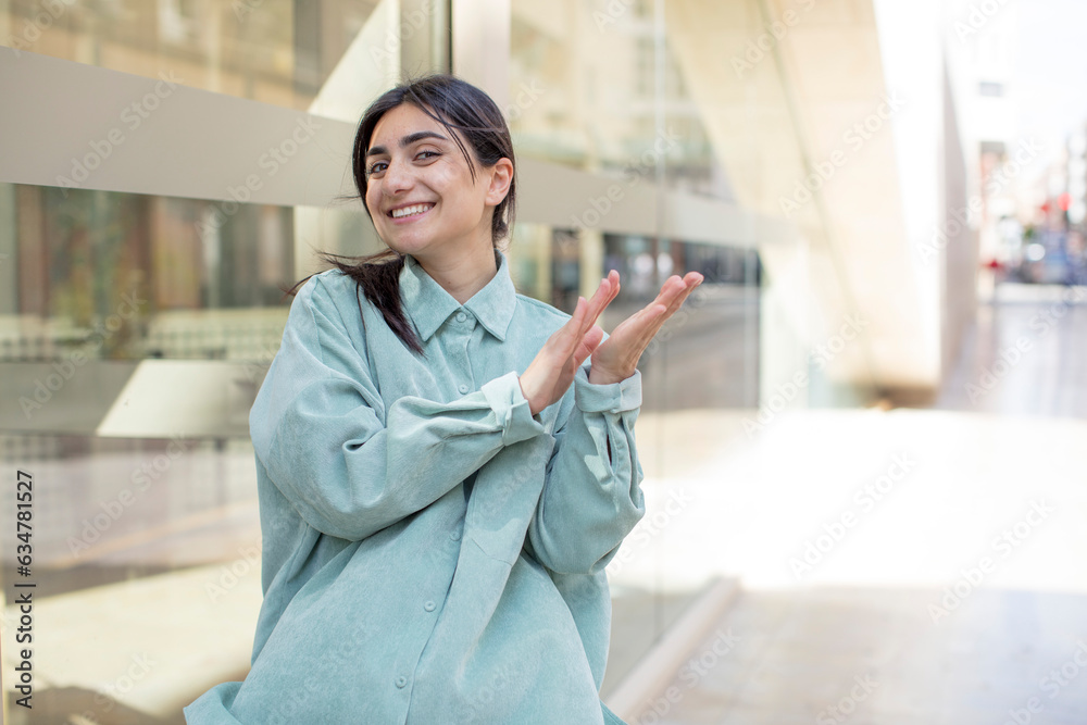 pretty woman feeling happy and successful, smiling and clapping hands ...