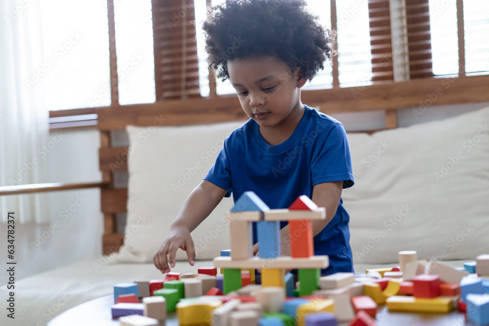 Little African American boy play with wooden colorful blocks ...