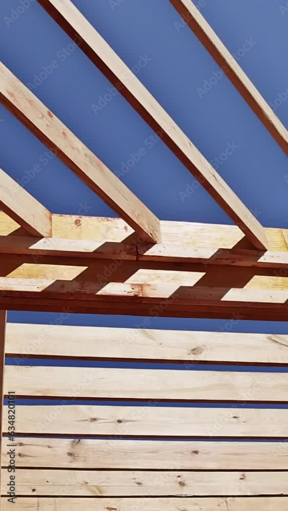 Wood frame truss roofing is constructed at new house construction site ...