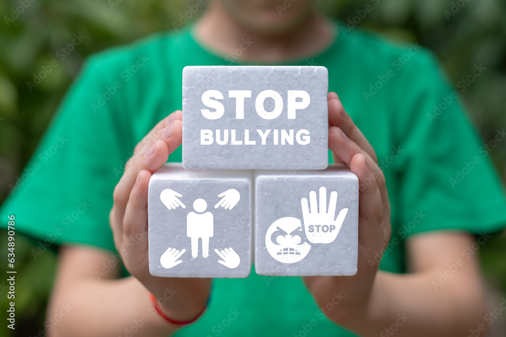 Schoolgirl holding white plastic foam blocks with inscription: STOP ...