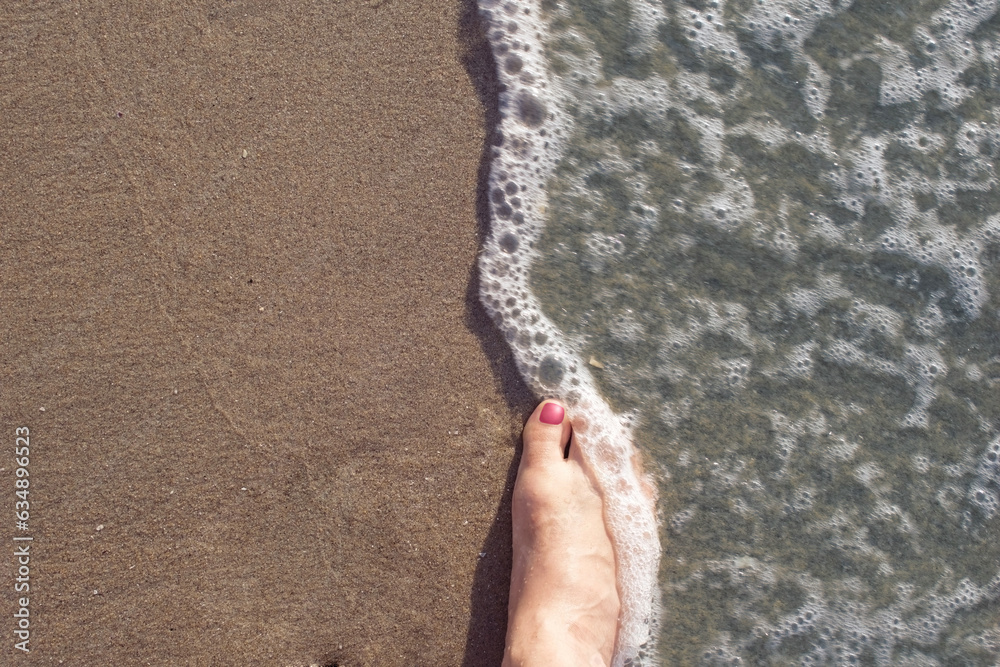 minimal beach sand and water with woman's foot step in curvy flow ...