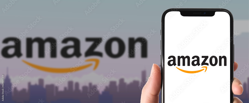 The logo of Amazon on the screen of a smartphone. Web banner horizontal ...