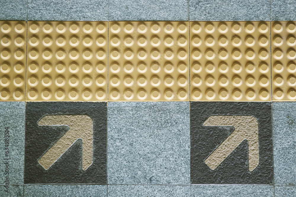 Yellow tactile paving and arrow sign of boarding direction on metro ...
