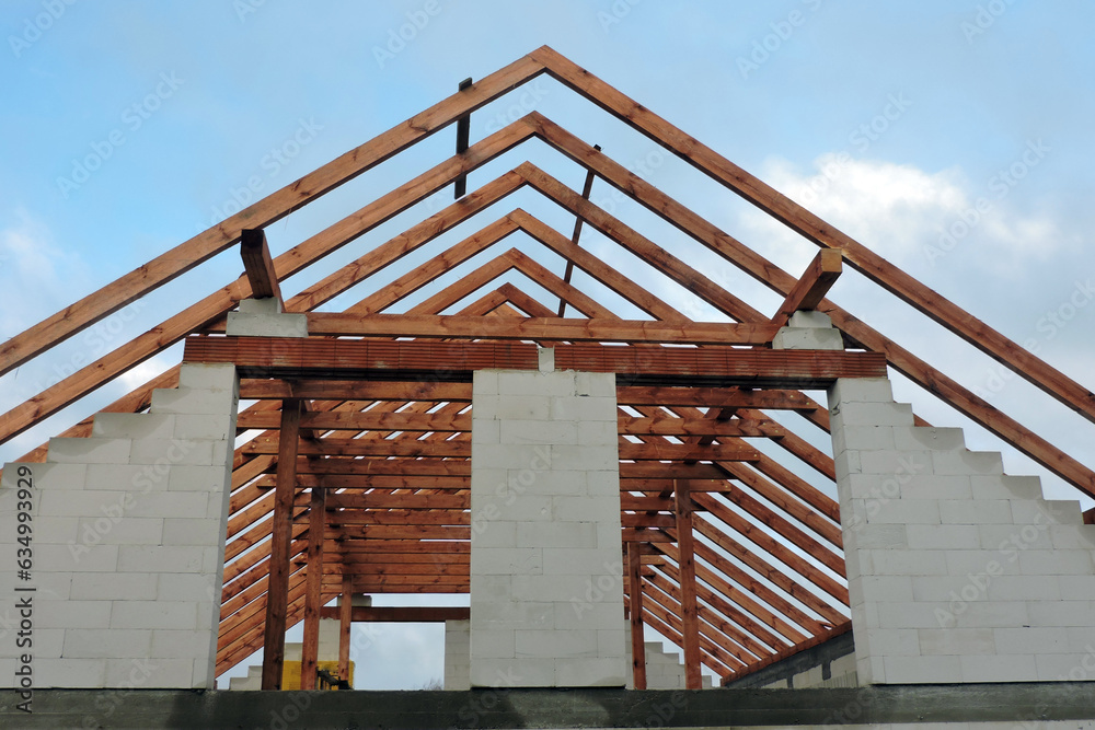 A timber roof truss in a house under construction, walls made of ...