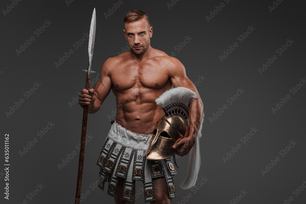 A muscular and attractive male model dressed in ancient pteruges poses ...