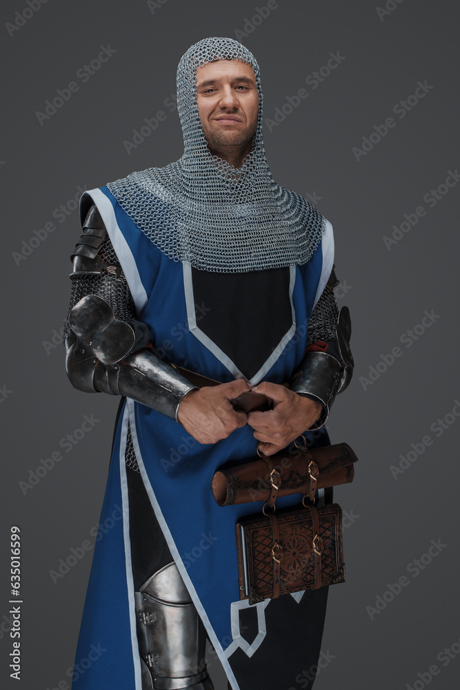 Medieval warrior garbed in shining armor, blue surcoat, and chainmail ...
