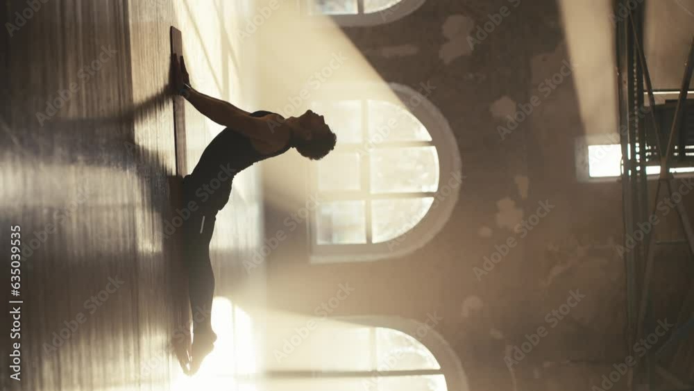 Vertical video of a male athlete in a black sports summer uniform doing ...