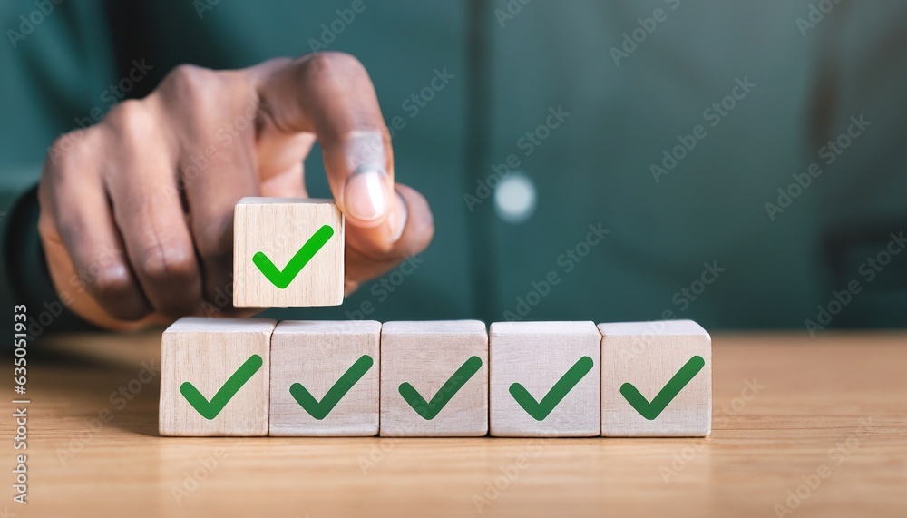 Foto de Wooden blocks checklist and green check mark icon with hand on ...