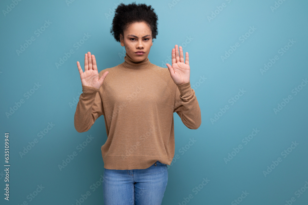 young strict pretty latin woman with curly hair on background with copy ...