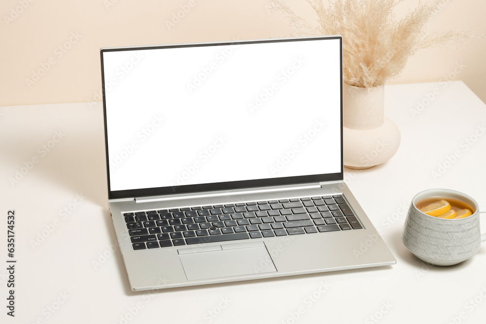 Laptop mockup with white screen, vase with pampas grass, cup of tea ...
