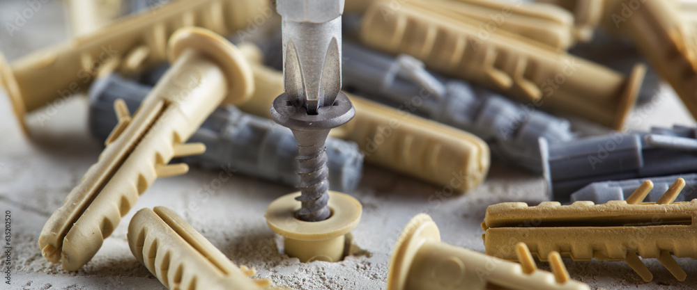 screwdriver screw and dowel in a concrete wall background Stock Photo ...