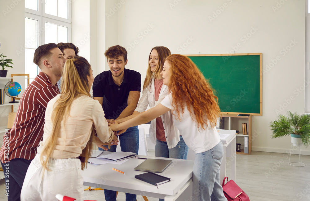 Small group of attractive happy students in casual clothes hold their ...