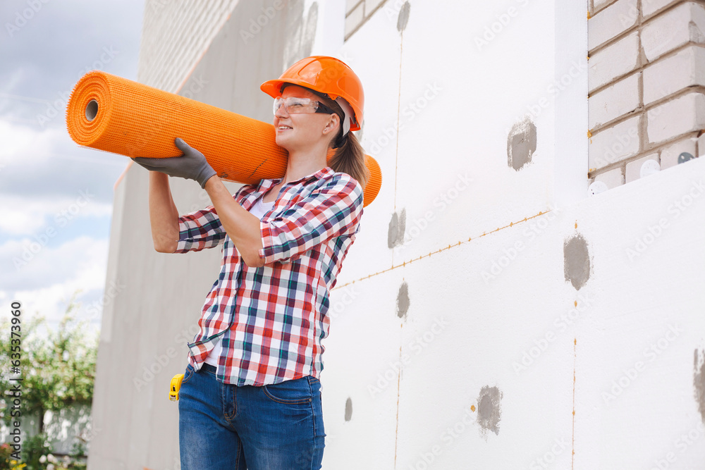 The woman with rolls of reinforcing fiberglass. Insulation of the house ...