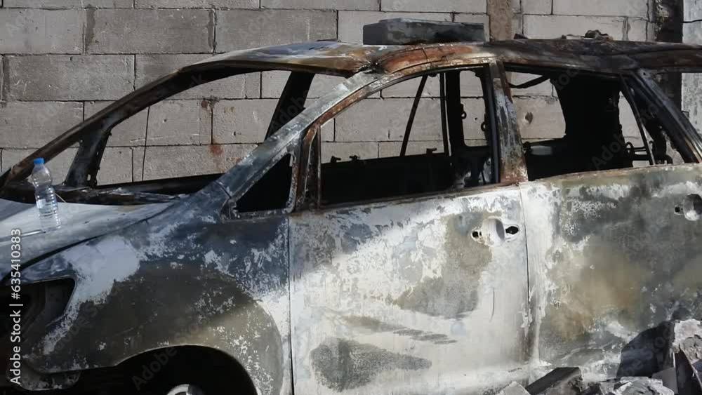 Pan Shot of a car caught on fire as a result of an exploding fuel oil ...