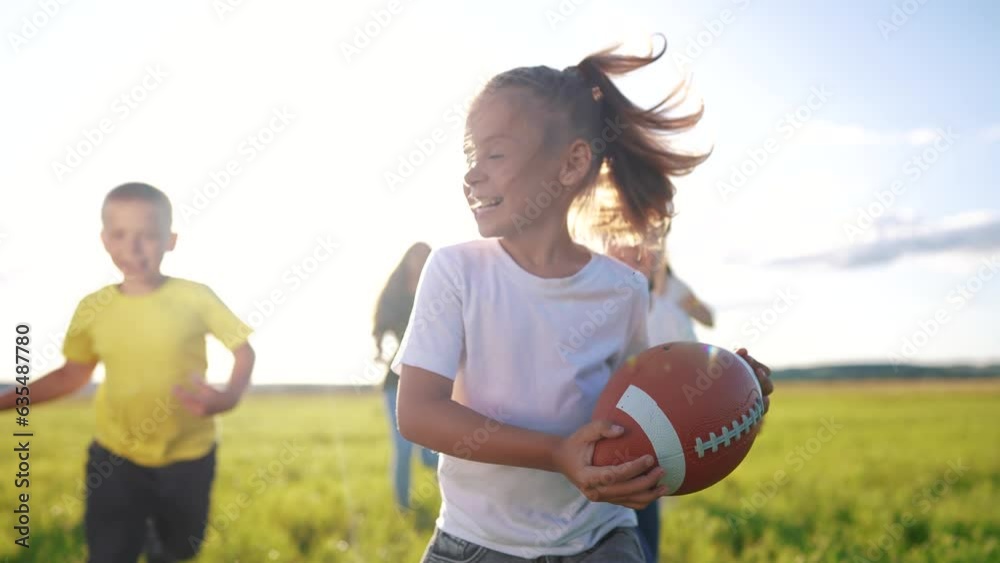children playing rugby in the park. a group of children play american ...