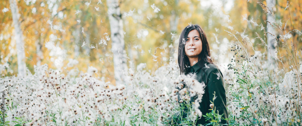 Dreamy beautiful girl in thistle thickets on bokeh background of yellow ...