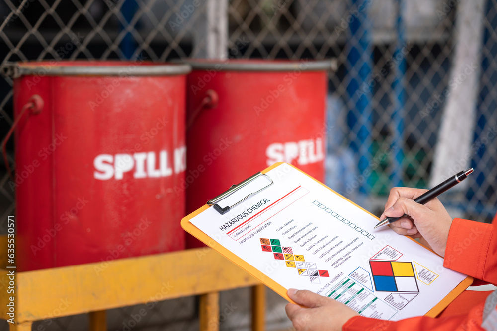 Action of safety officer is checking chemical hazard material form for ...