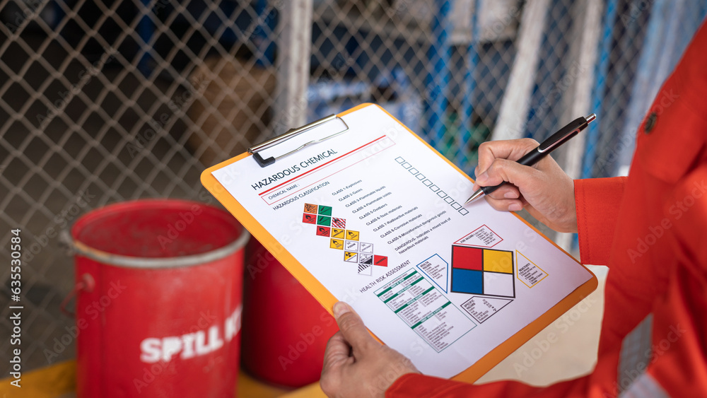 Action of safety officer is checking chemical hazard material form for ...