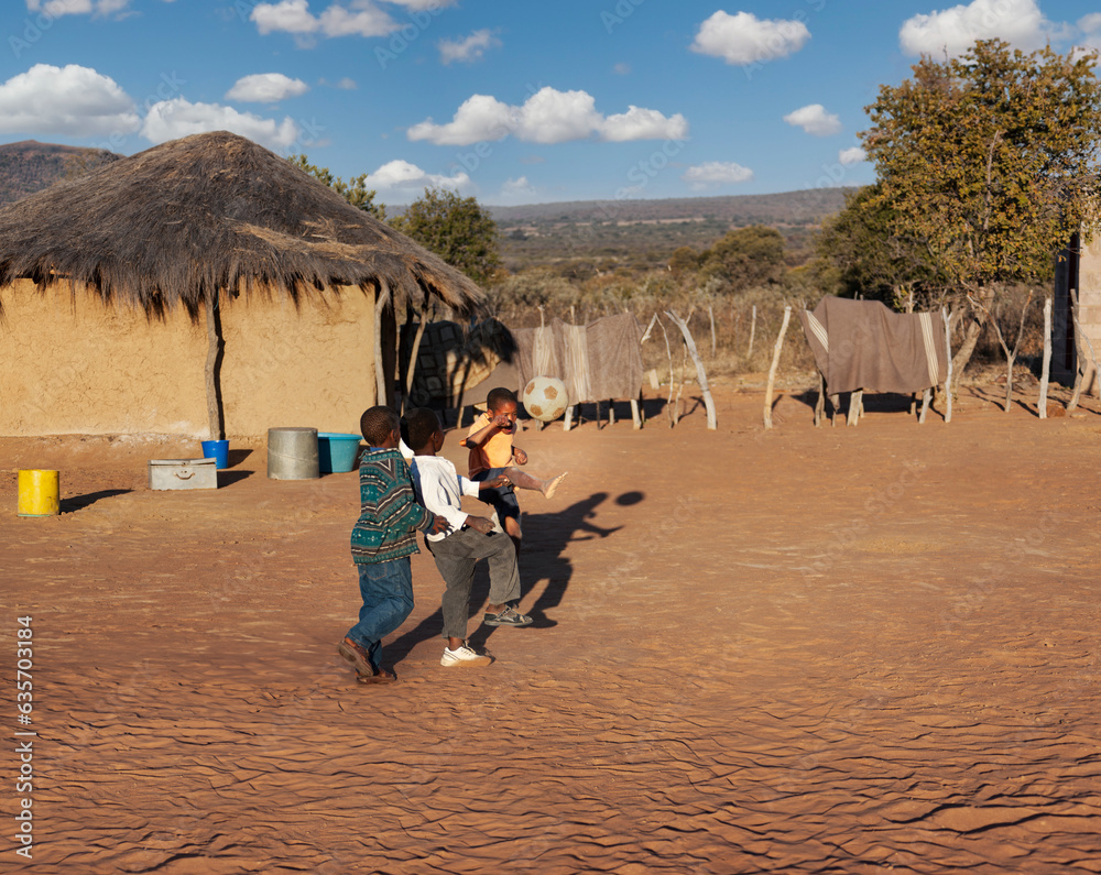 village african kids playing soccer on an improvised football field in ...