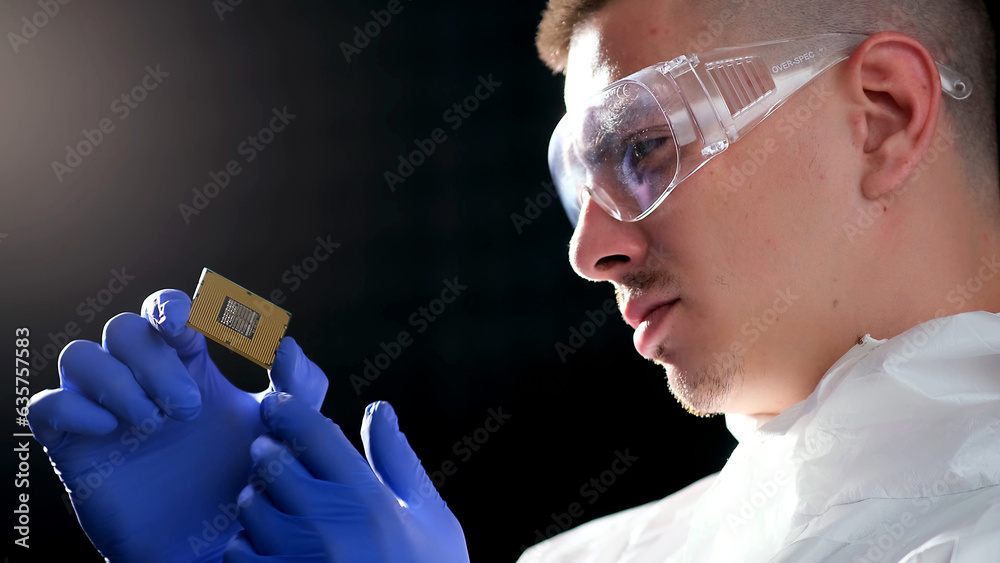 Close up portrait of a young computer engineer with a microchip ...