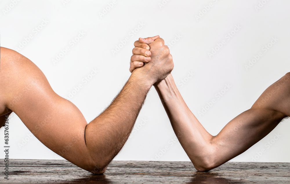 Heavily muscled man arm wrestling a puny weak man. Two man's hands ...
