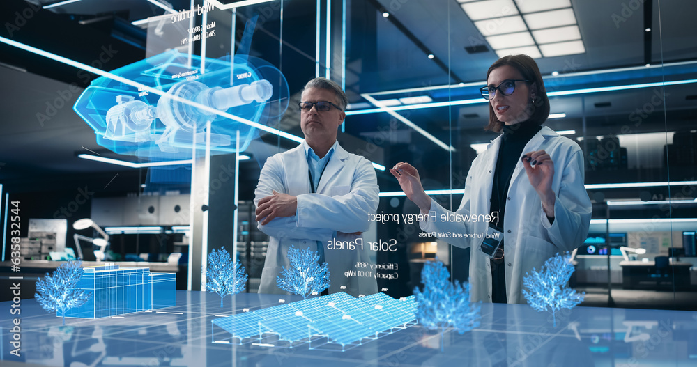 Male And Female Renewable Energy Engineers Using Futuristic Hologram of ...