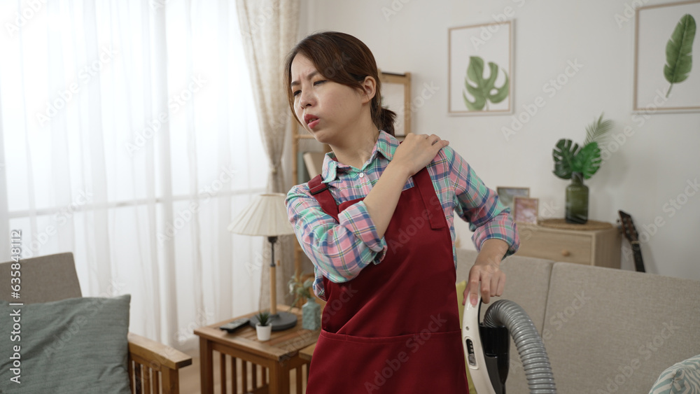 side view of tired attractive young asian woman having pain in neck ...