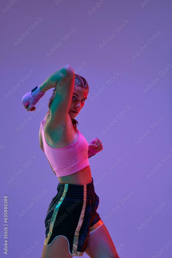 Athletic, serious and concentrated teen girl, MMA fighter training ...