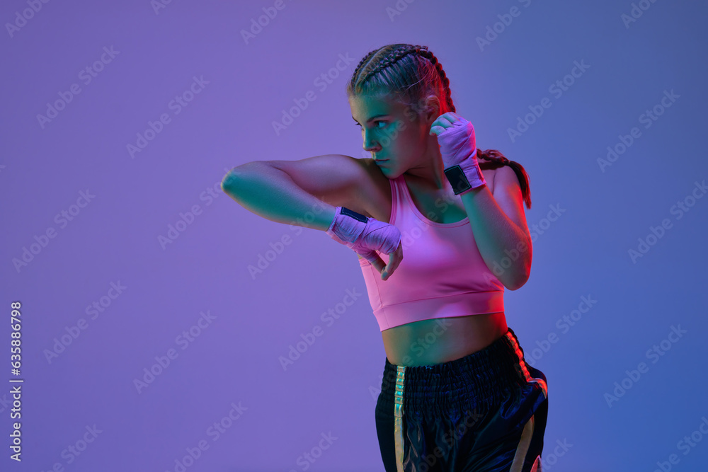 Teen athletic girl, MMA fighter in motion, training kicks against ...