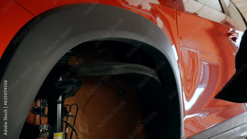 The car mechanic removes the plastic spacers of the front arches of the ...