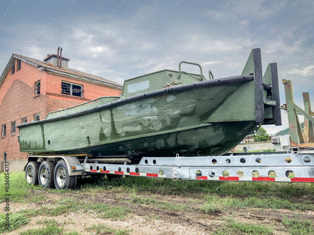 old army decommissioned river boat (bridge erection boat) on a trailer ...